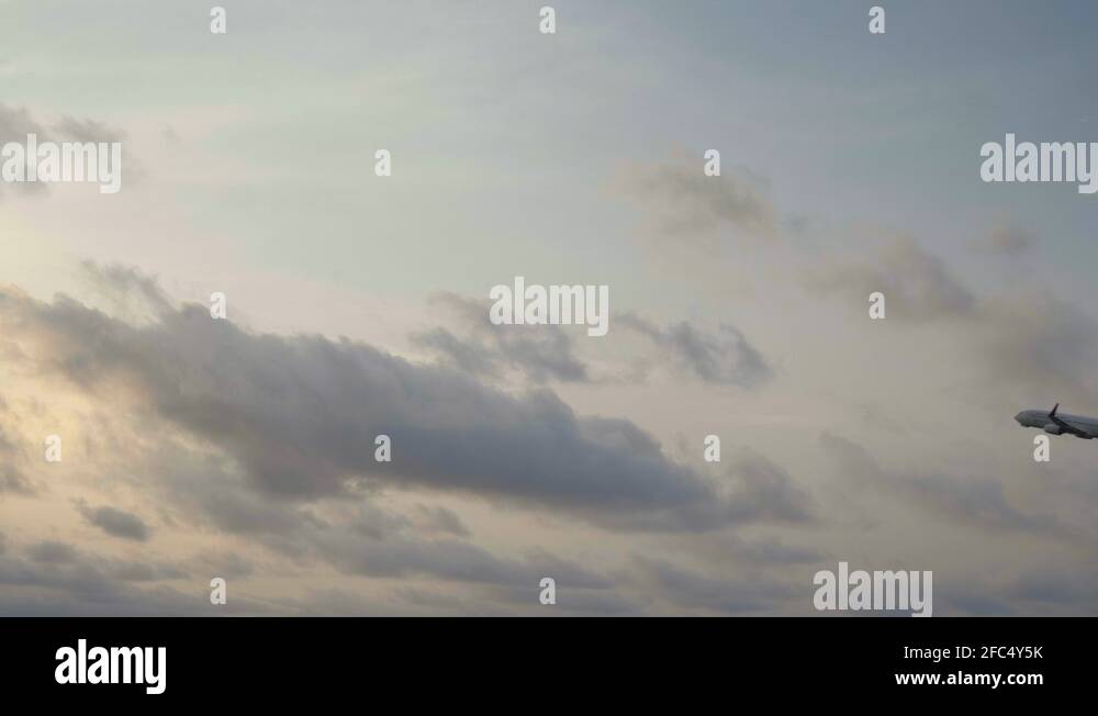 Small jet airplane is taking off in sunset with blue sky and clouds ...