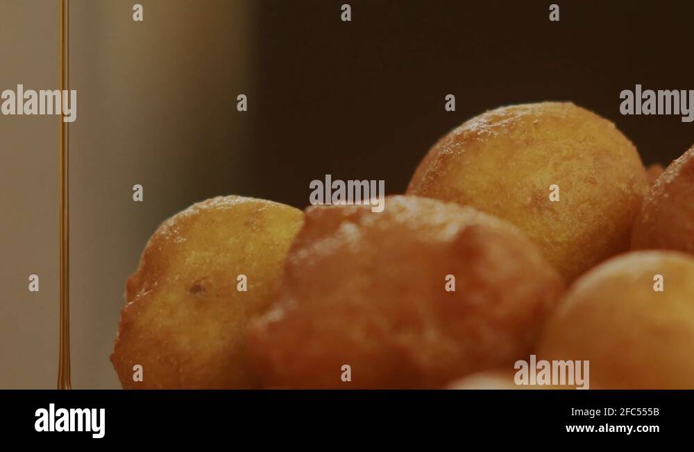 Close-up on Turkish fried donuts Lokma pour thick honey. 4K Slow Motion ...