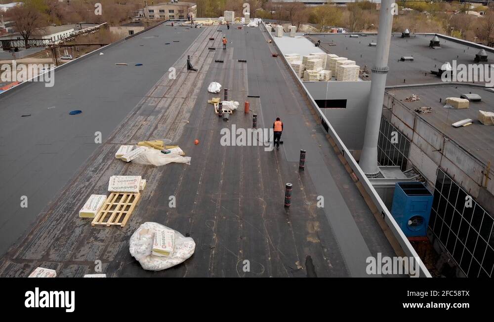 Workers at a construction site. The process of hydro insulation of the ...