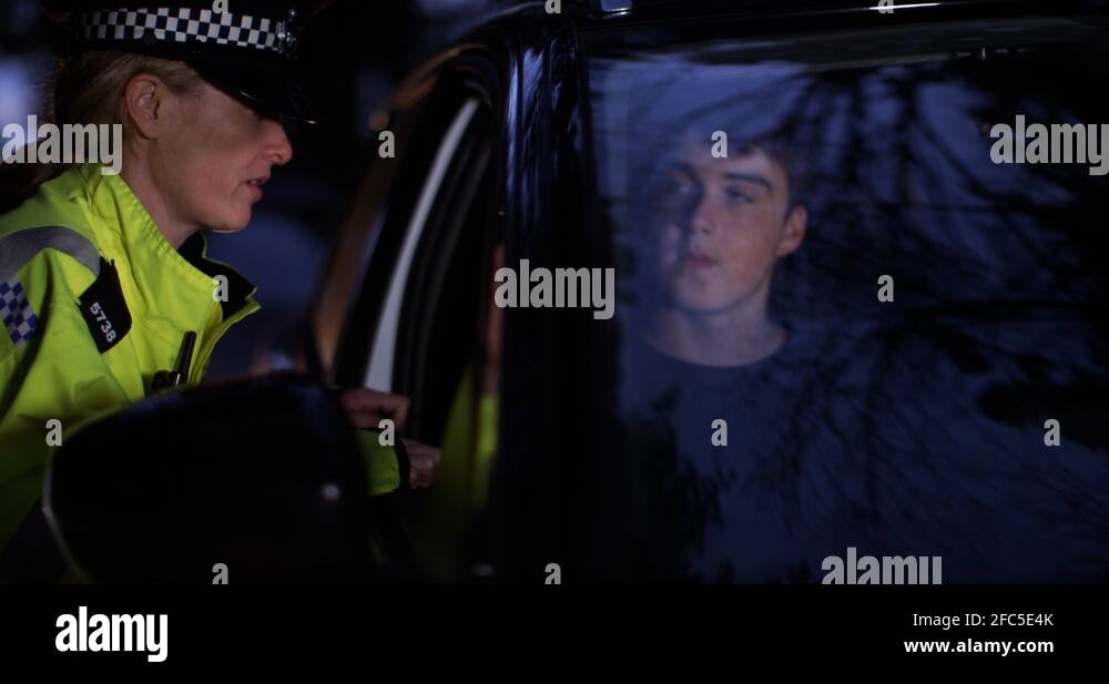 4K Female cop checking young man's driver's license at the car window ...