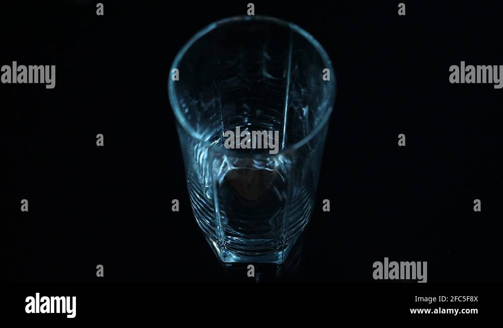 Clean water pouring in empty glass, black backdrop, locked off Stock ...