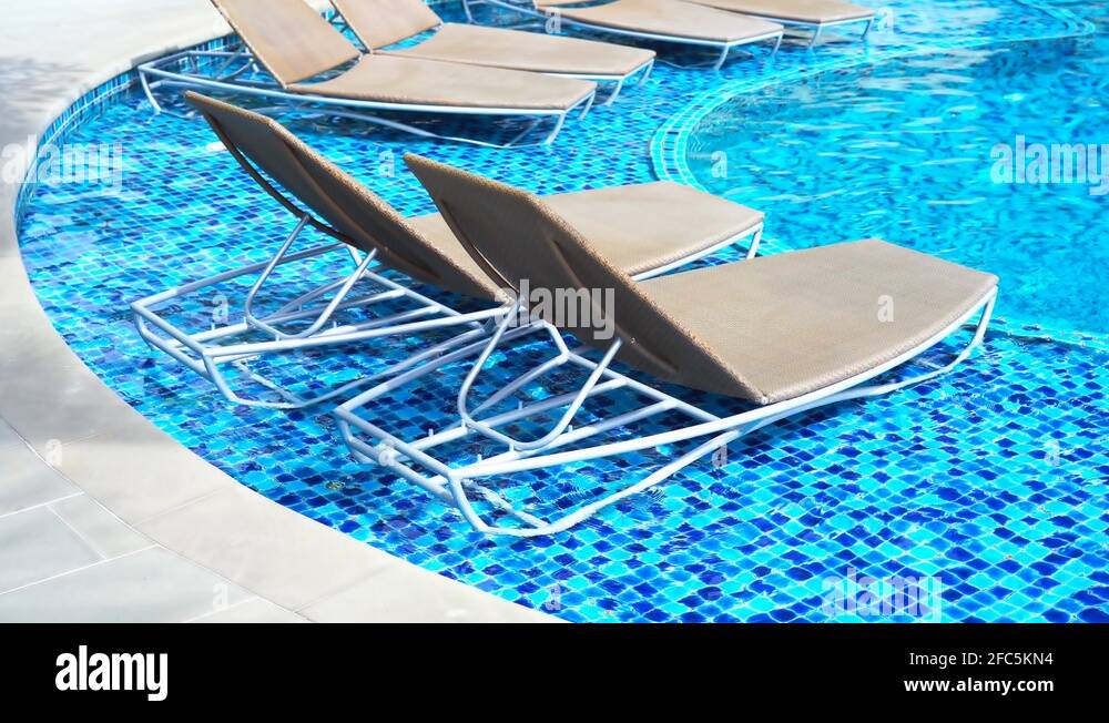 Chairs for sunbathing and relaxing in shallow water of a crystal clear ...