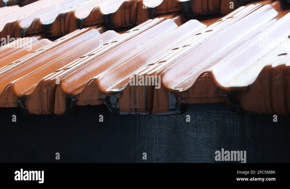 A rain fall on a roof. The stream of rainwater flows into the eaves ...