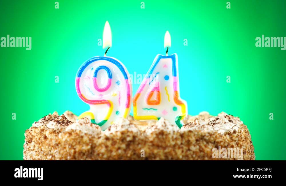 Birthday cake with a burning birthday candle. Number 94. Background ...