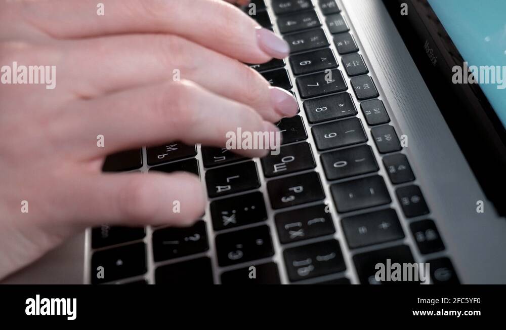 Female hands press keys on the keyboard of a MacBook with a Russian ...