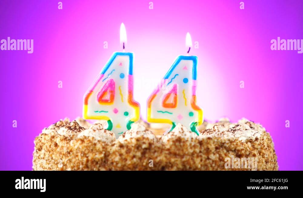 Birthday cake with a burning birthday candle. Number 44. Background ...