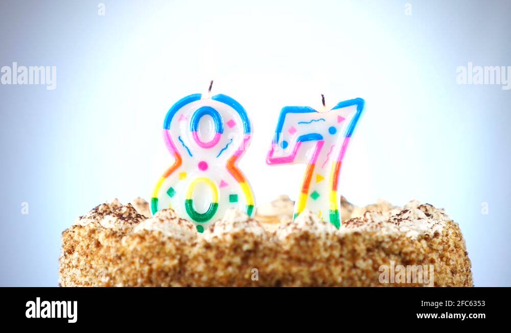 Birthday cake with a burning birthday candle. Number 87. Background ...
