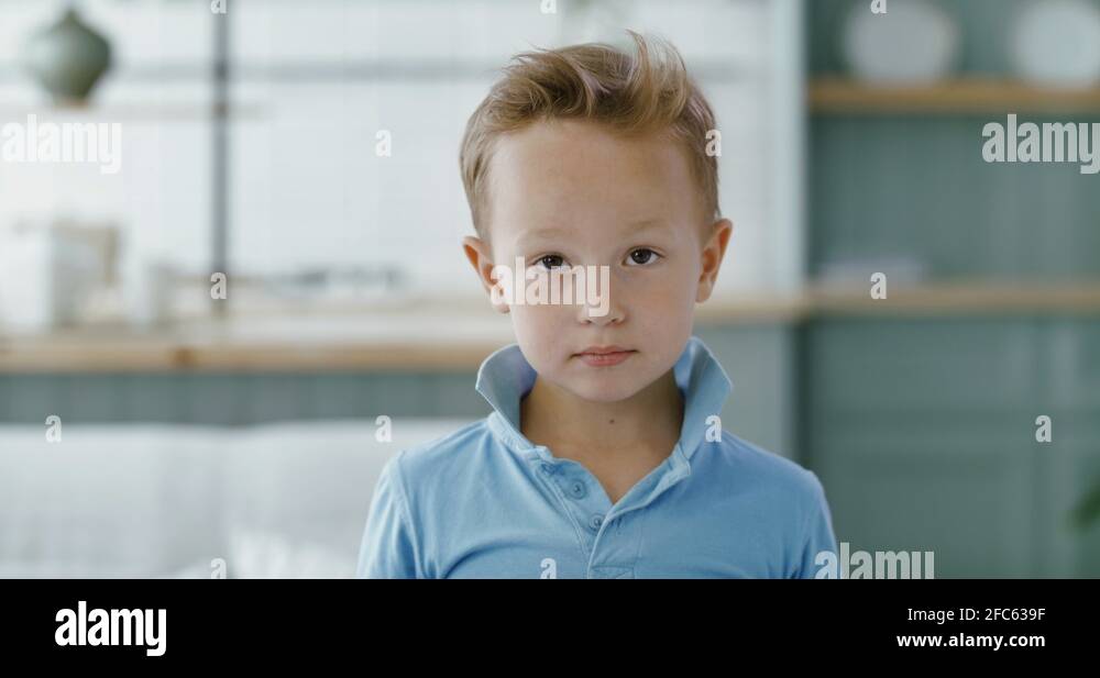 Portrait of cute Caucasian kid boy doing silly funny face, looking into ...