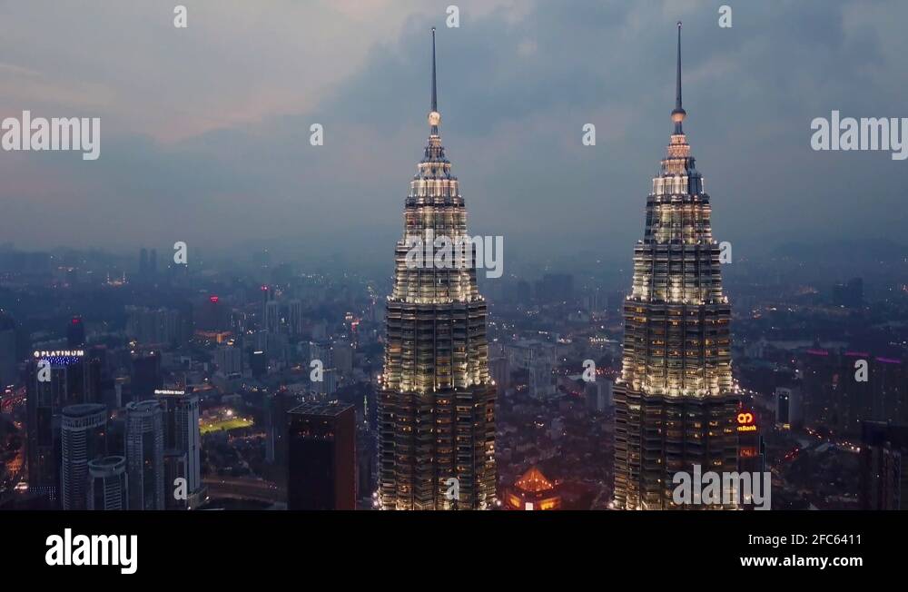 Petronas Twin Towers top at dusk with KL background, aerial tilt Stock ...