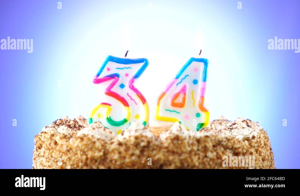 Birthday cake with a burning birthday candle. Number 34. Background ...