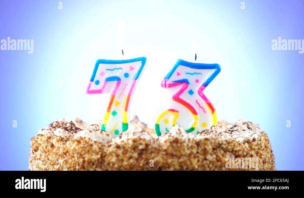 Birthday cake with a burning birthday candle. Number 73. Background ...