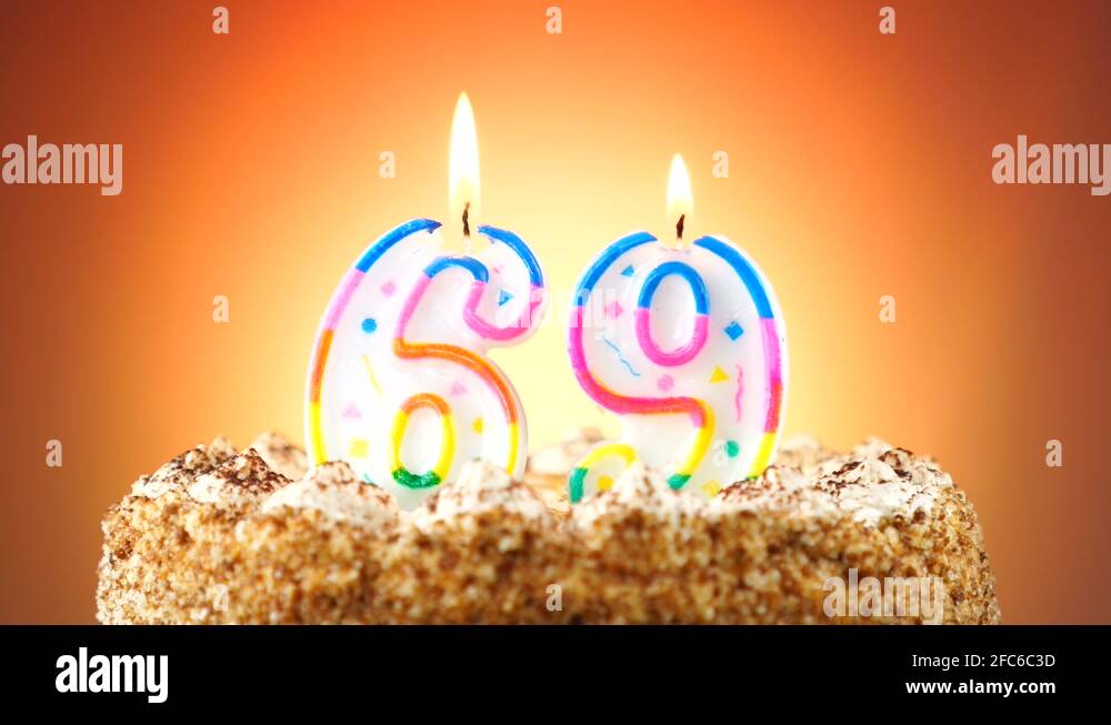 Birthday cake with a burning birthday candle. Number 69. Background ...