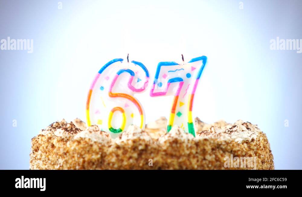 Birthday cake with a burning birthday candle. Number 67. Background ...