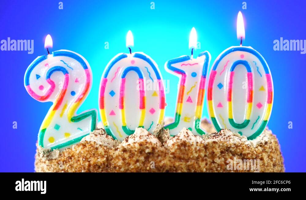 Birthday cake with a burning birthday candle. Number 2010. Background ...