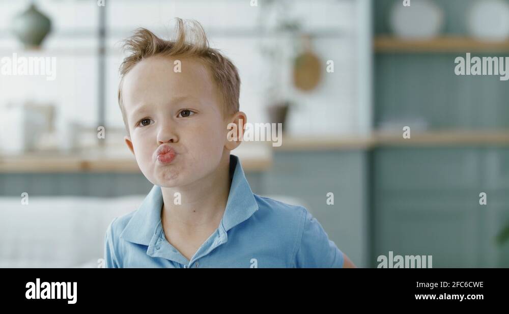 Portrait of cute Caucasian kid boy doing silly funny face, looking into ...