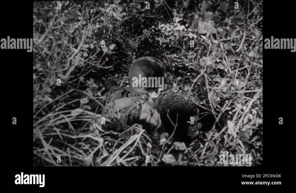 1940s: Soldier hiding in bushes, zoom out. Soldiers walking, fall to ...