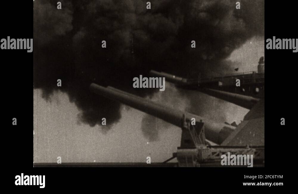 1940s: Ship guns firing. Men loading ammunition. View of battleship ...