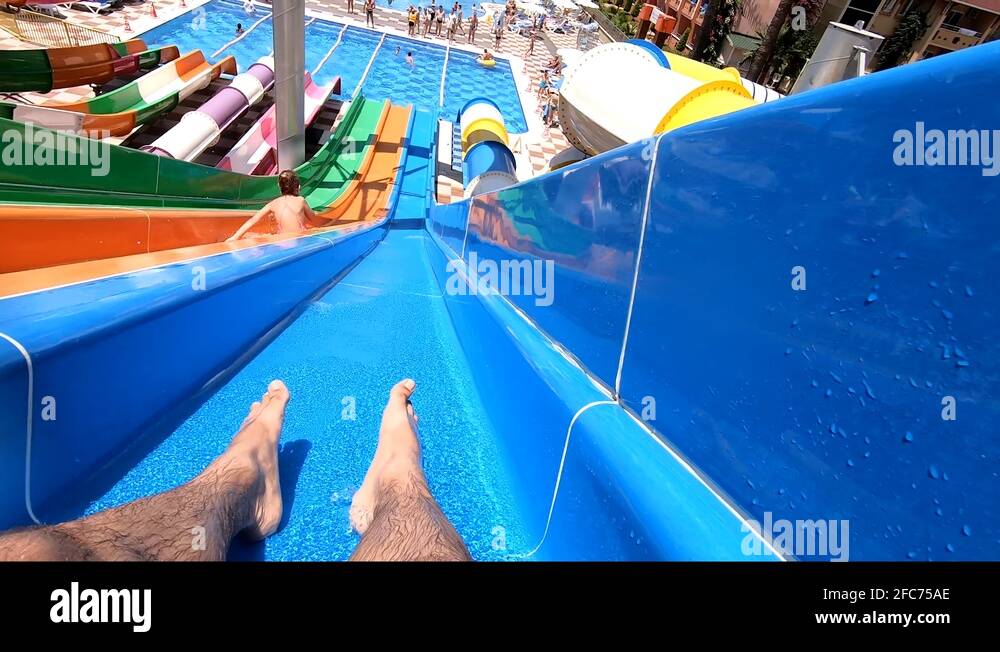 Man having fun on a water slide. Cool people having fun on the water ...