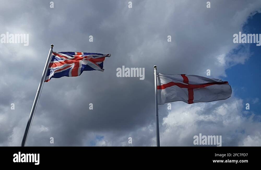 Fluttering Union Jack and England flag on a windy overcast day Stock ...