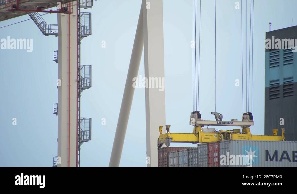 Close up crane loading containers on ocean cargo ship at Port of Koper ...