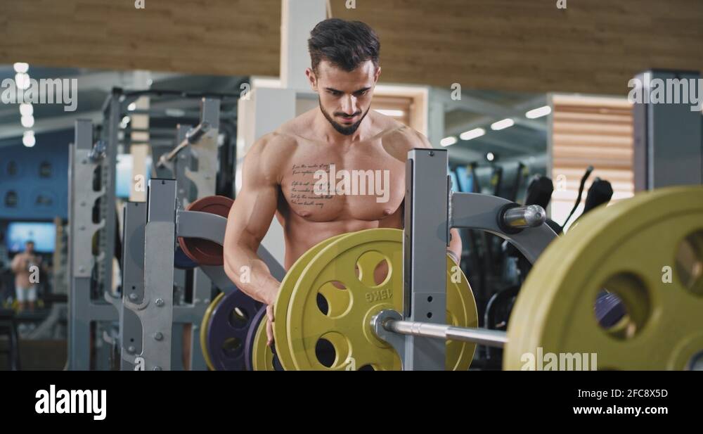 An enchanting young built man, does some heavy lifting to build up his ...