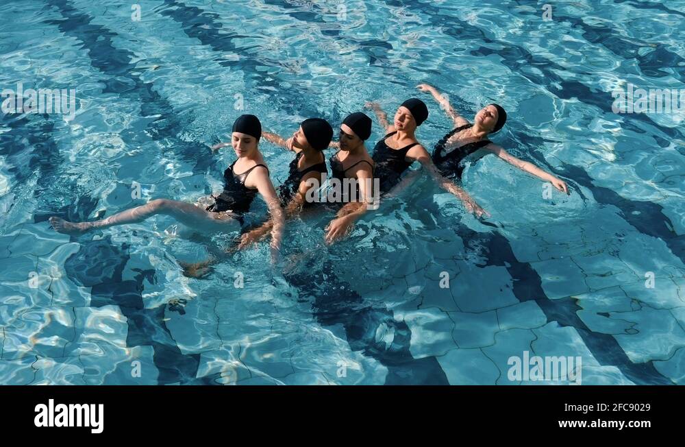 Five girls swim on their backs in an outdoor pool. Relax in the summer ...
