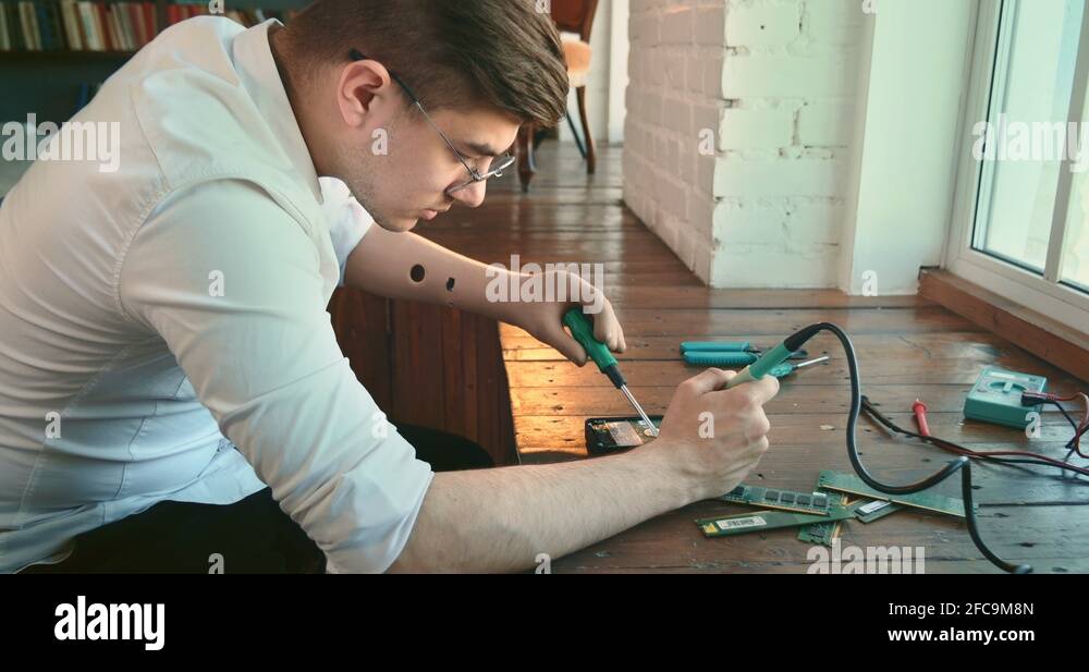 Workplace of amputee invalid. Man with artificial hand working ...