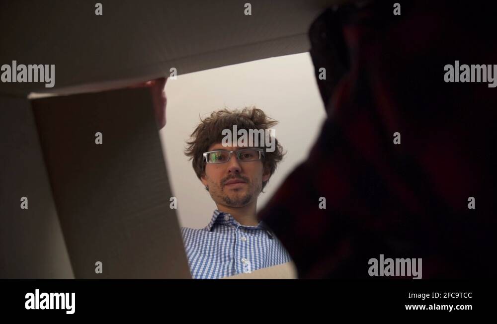 A man looking inside a cardboard box and takes out her book bought in a ...