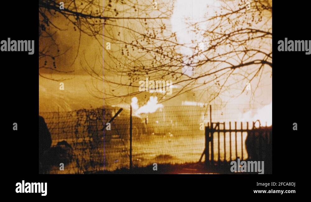 1950s: UNITED STATES: plant storage containers on fire. Flame above ...
