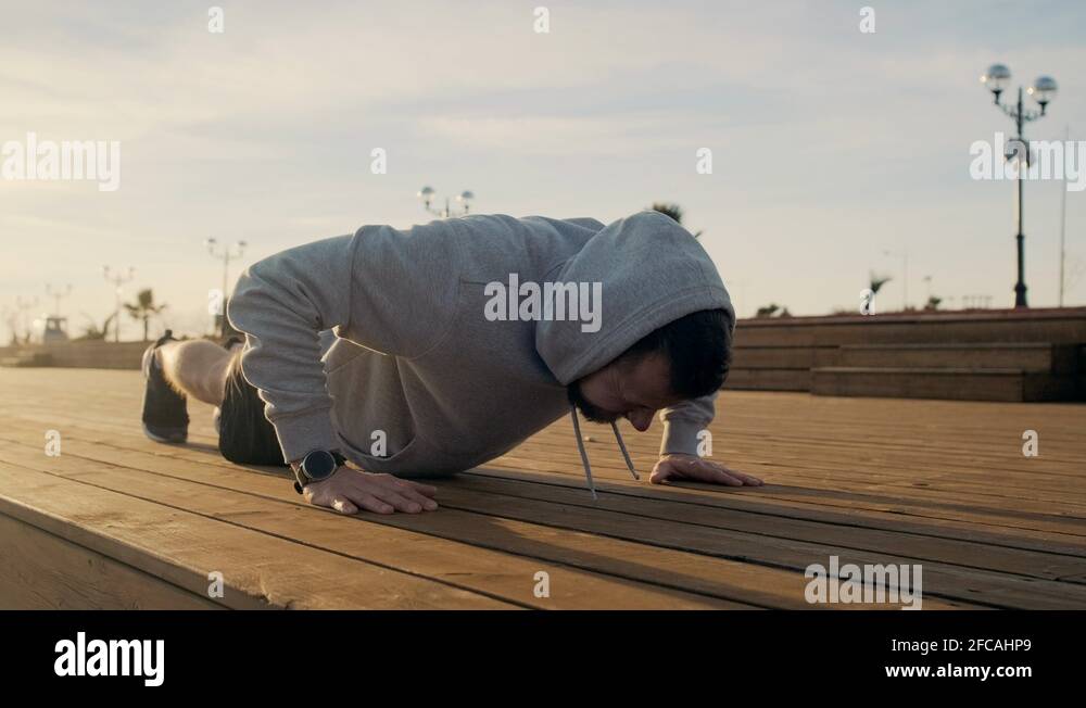 Exhausted man is doing push-ups and falling on ground without force ...