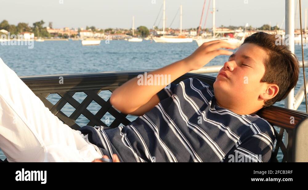 Handsome teenage boy relaxing at the yacht deck 2 Stock Video Footage ...