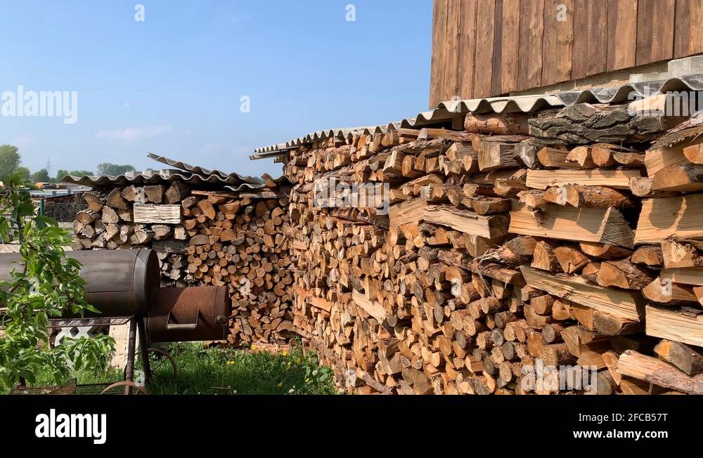 Stacked stockpile of chopped log wood in outdoor storage with rustic ...