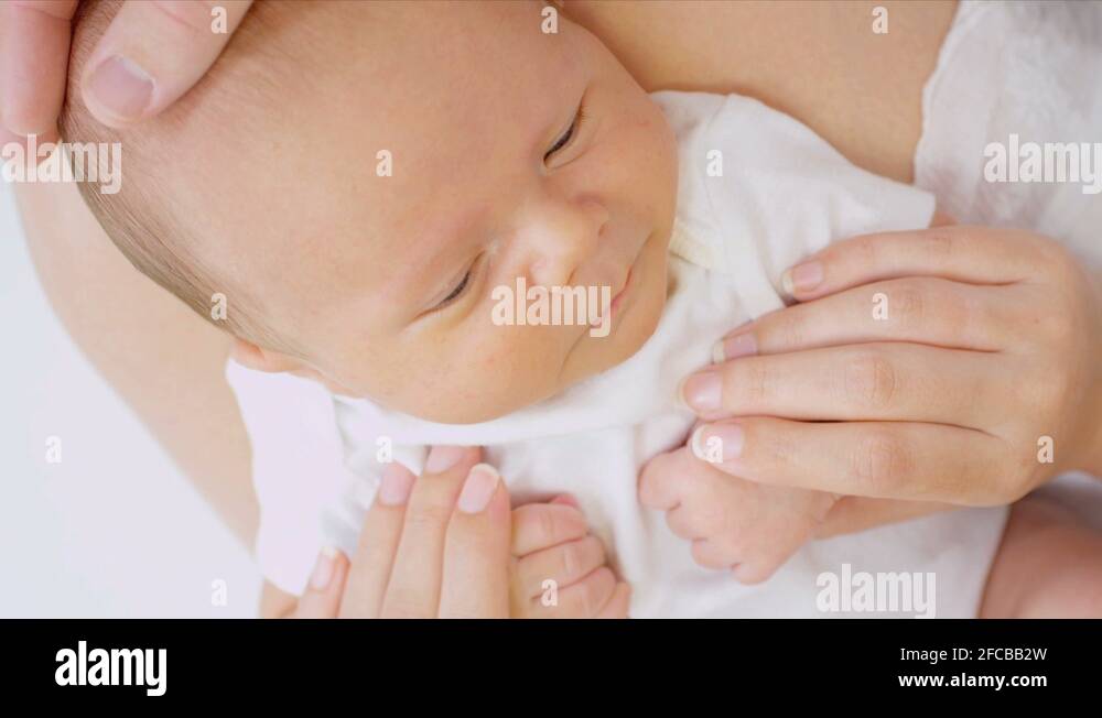 Young hands holding newborn baby Stock Video Footage - Alamy