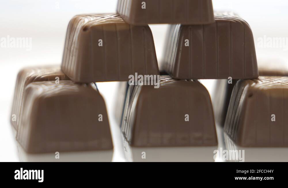 Pyramid of chocolate sweets rotating on white background close-up Stock ...