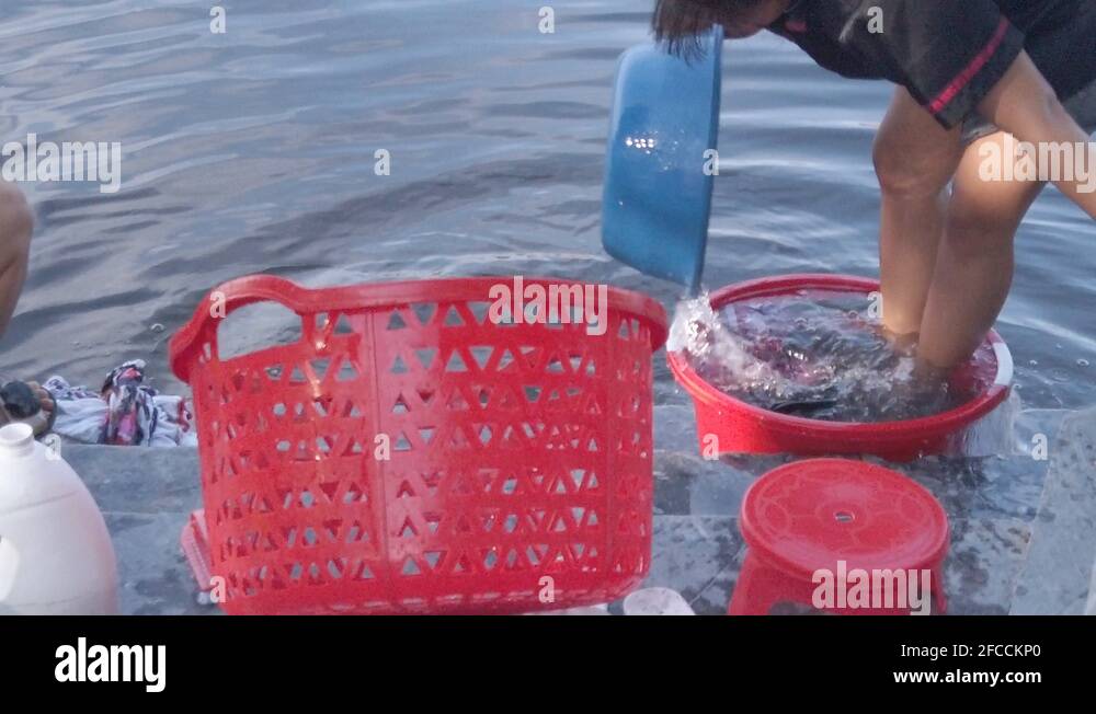 Asiatic young woman doing laundry with feet. Vietnamese female ...