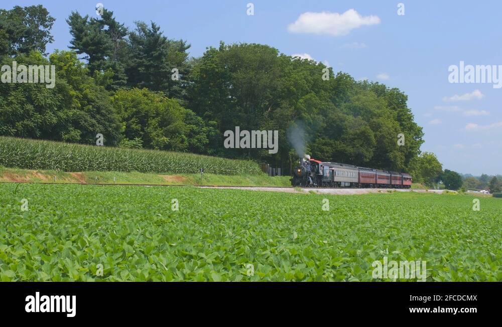 A 1910 Steam Engine with Passenger Train Pulling into a Station Puffing ...