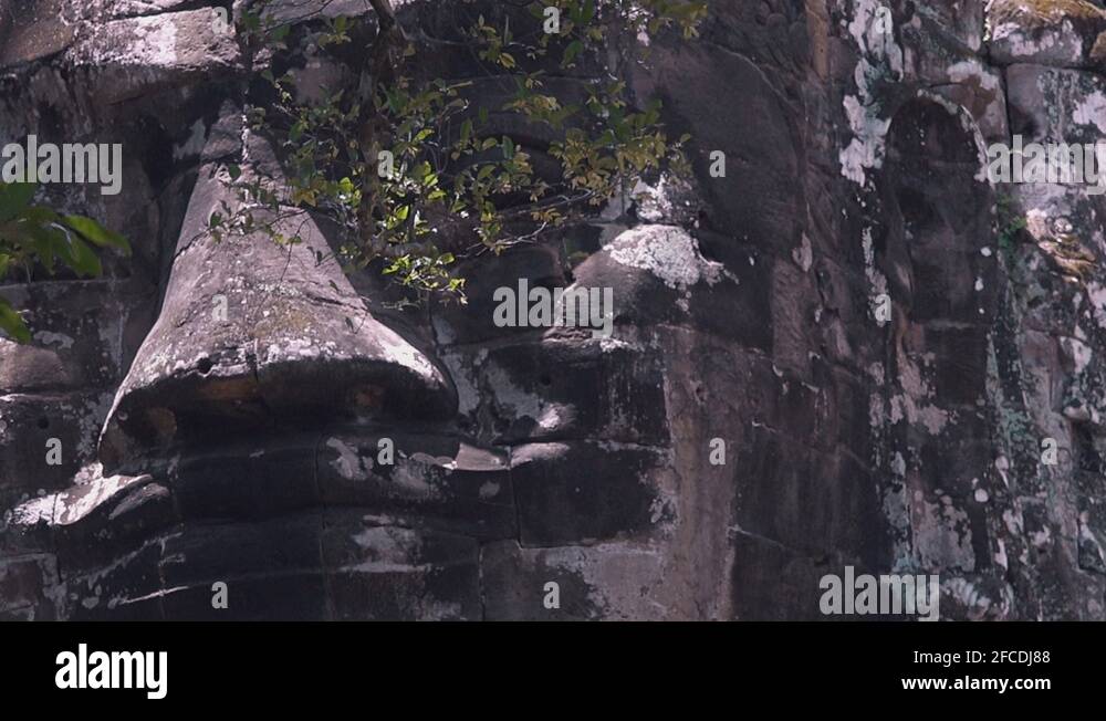 Zoom Out From Large Stone Face In The Jungle of Angkor Wat Stock Video ...