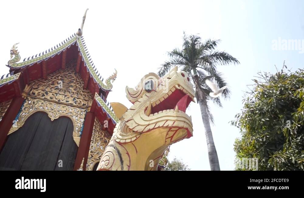 Iconic dragon statue located next to a temple with a palm tree in the ...