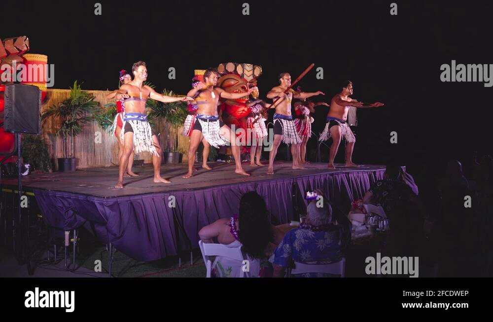 A group of dancers dance and chant in unison on stage at a luau Stock ...