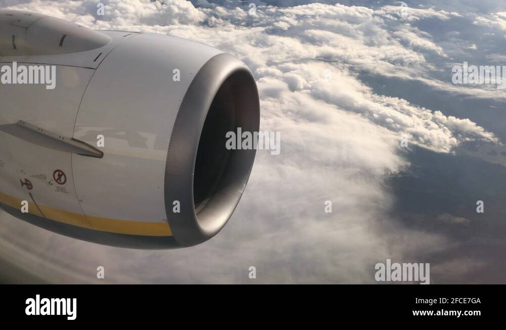 Aircraft turbine engine wing above floating foamy clouds, window Stock ...