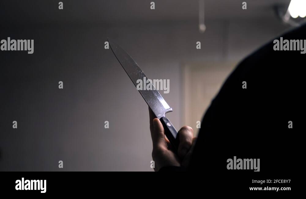 A scary slasher killer holding a terrifying knife in silhouette to ...