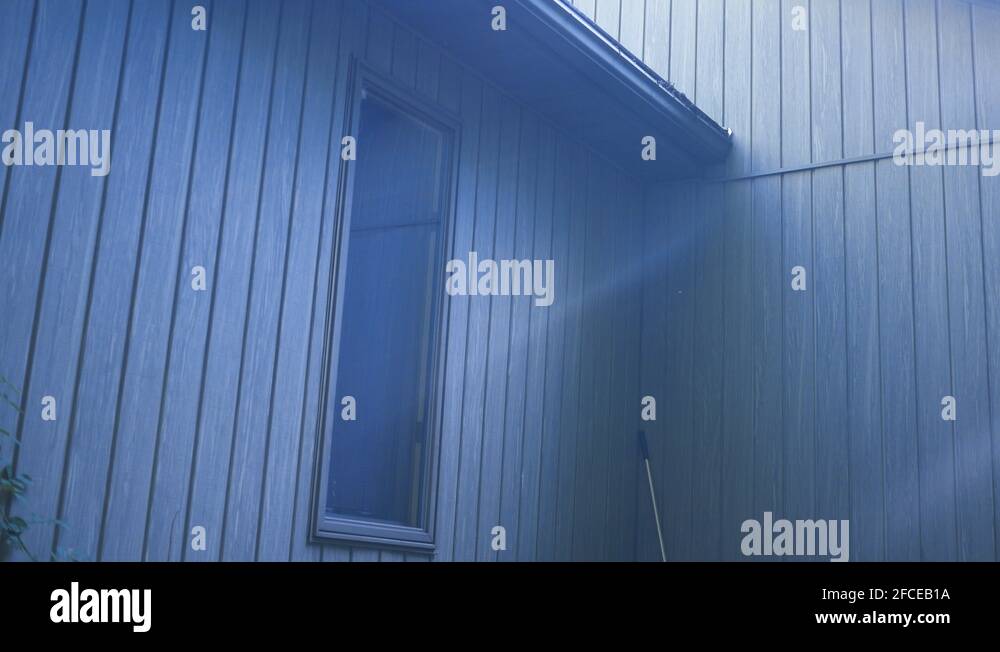 An establishing shot of a window of a 1980's modern home with lens ...