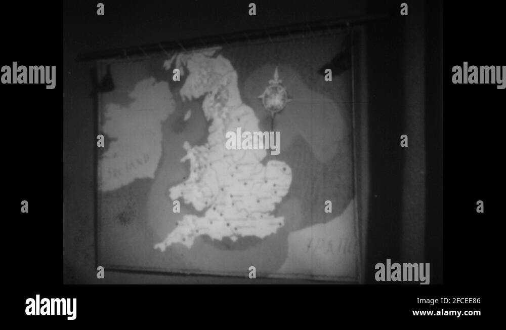 1950s: UNITED STATES: map of Britain. Men look at map. Men talk in room ...