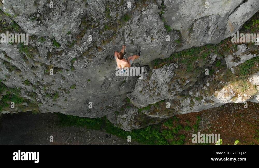 Top Down View Of Shirtless Male Climber Rappelling Down Rock Face. Slow ...