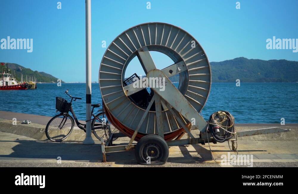This shot depicts a view of giant rope/cable reel with a backdrop to ...