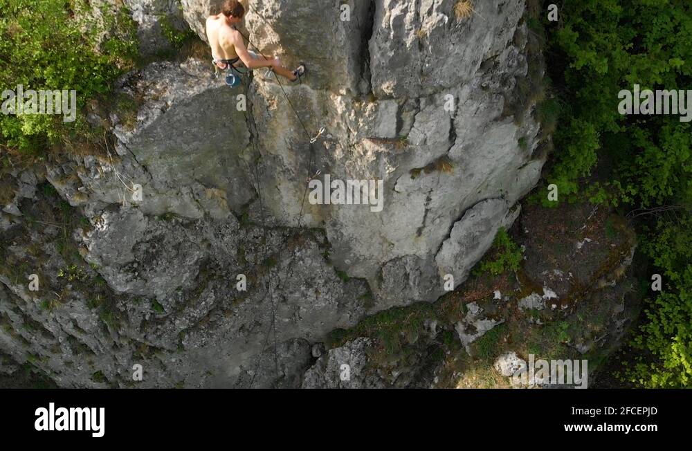 Top Down View Of Shirtless Male Climber Rappelling Down Rock Face ...