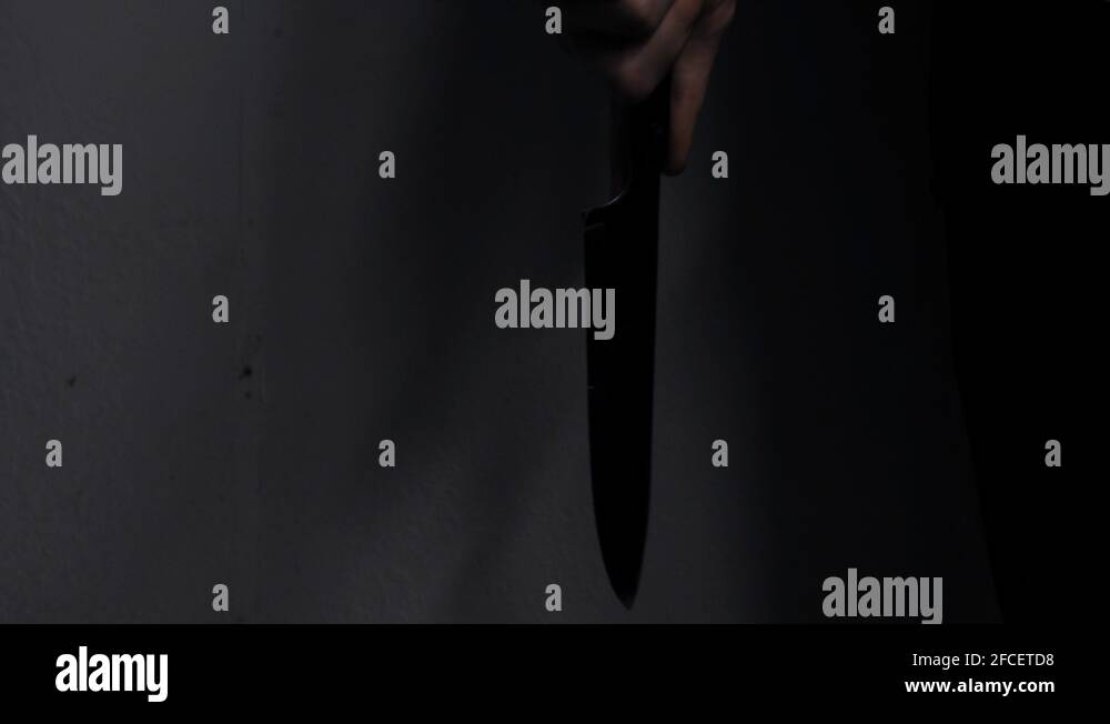 A scary slasher killer holding a terrifying knife weapon before ...