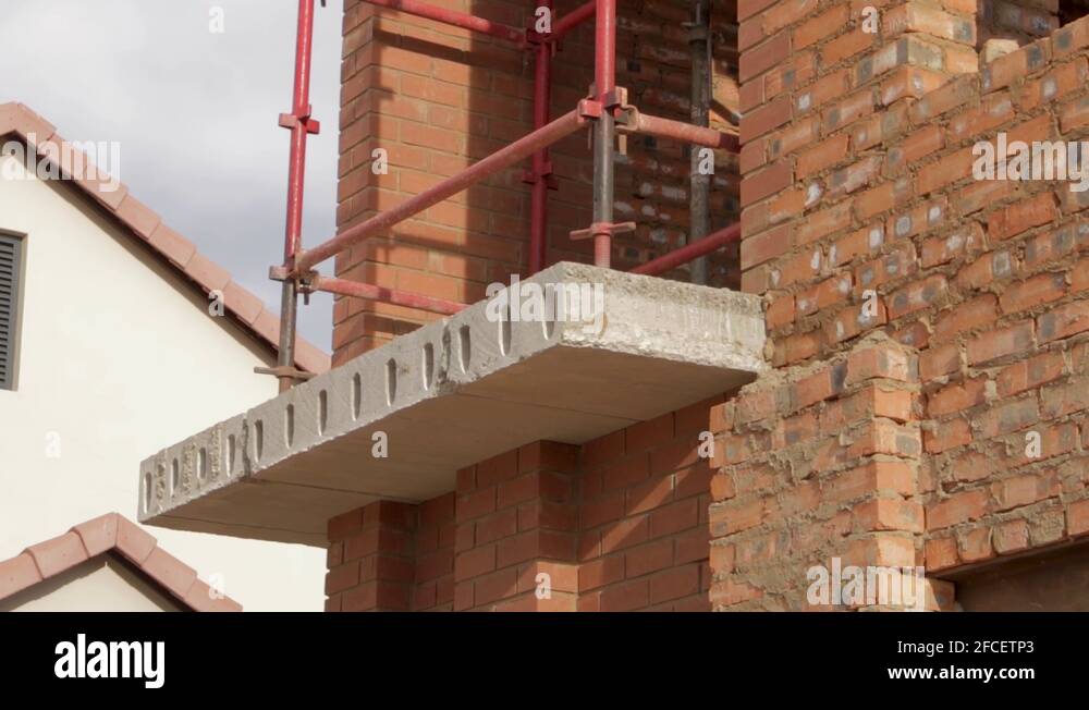Tilt shot of new house construction site showing scaffolding and brick ...