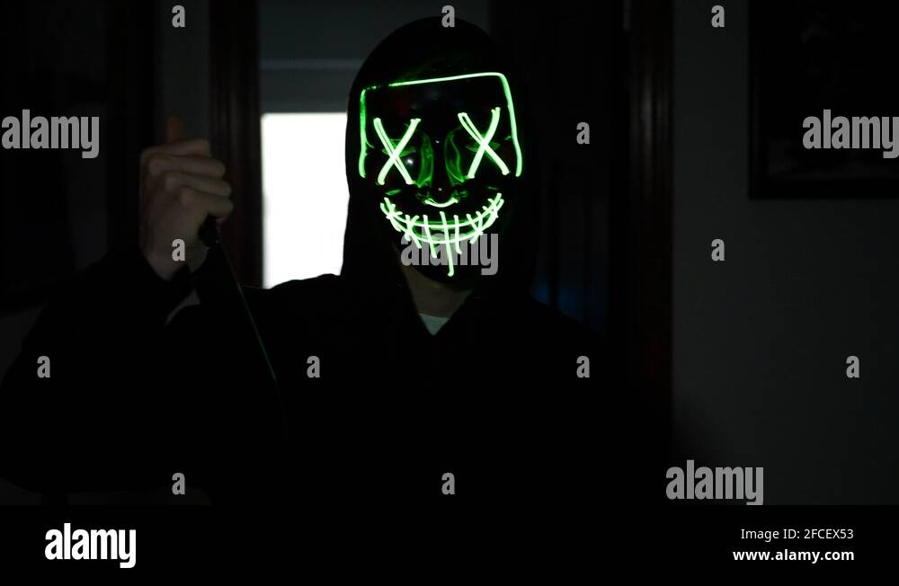 A terrifying killer in a generic halloween mask chasing a scared murder ...