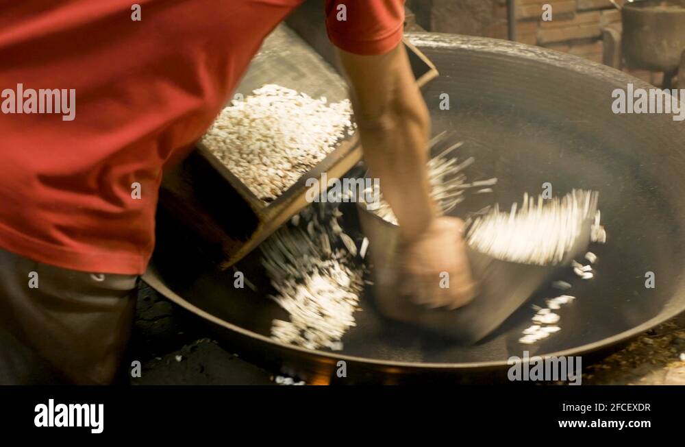 Popped rice is scooped and sifted by hand on the Mekong River Delta ...